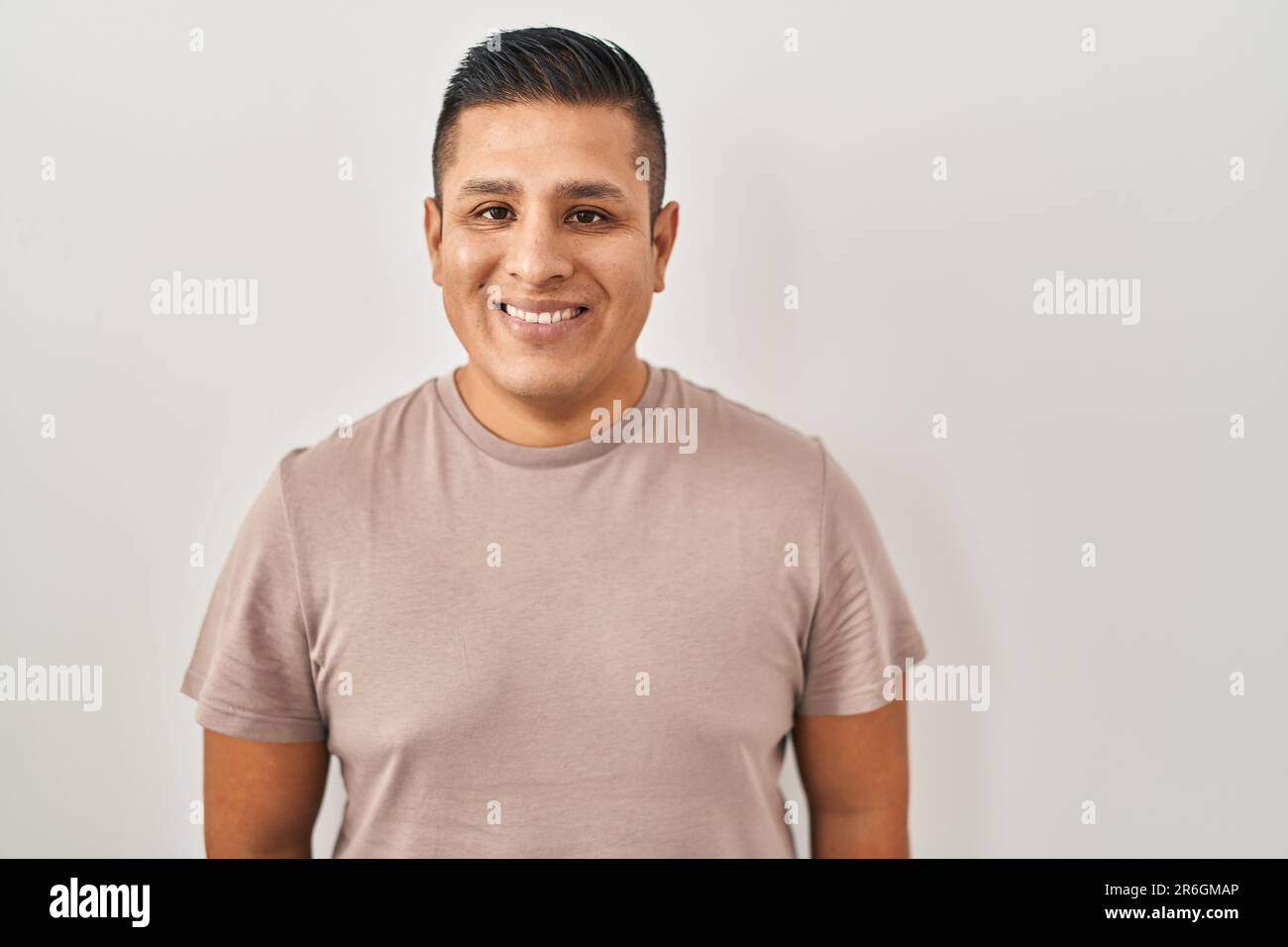 Hispanic young man standing over white background with a happy and cool ...