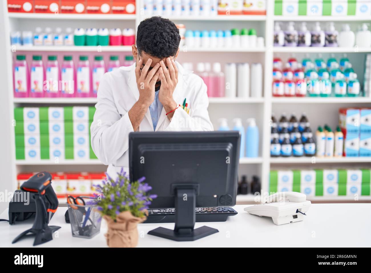 Hispanic man with beard working at pharmacy drugstore with sad ...