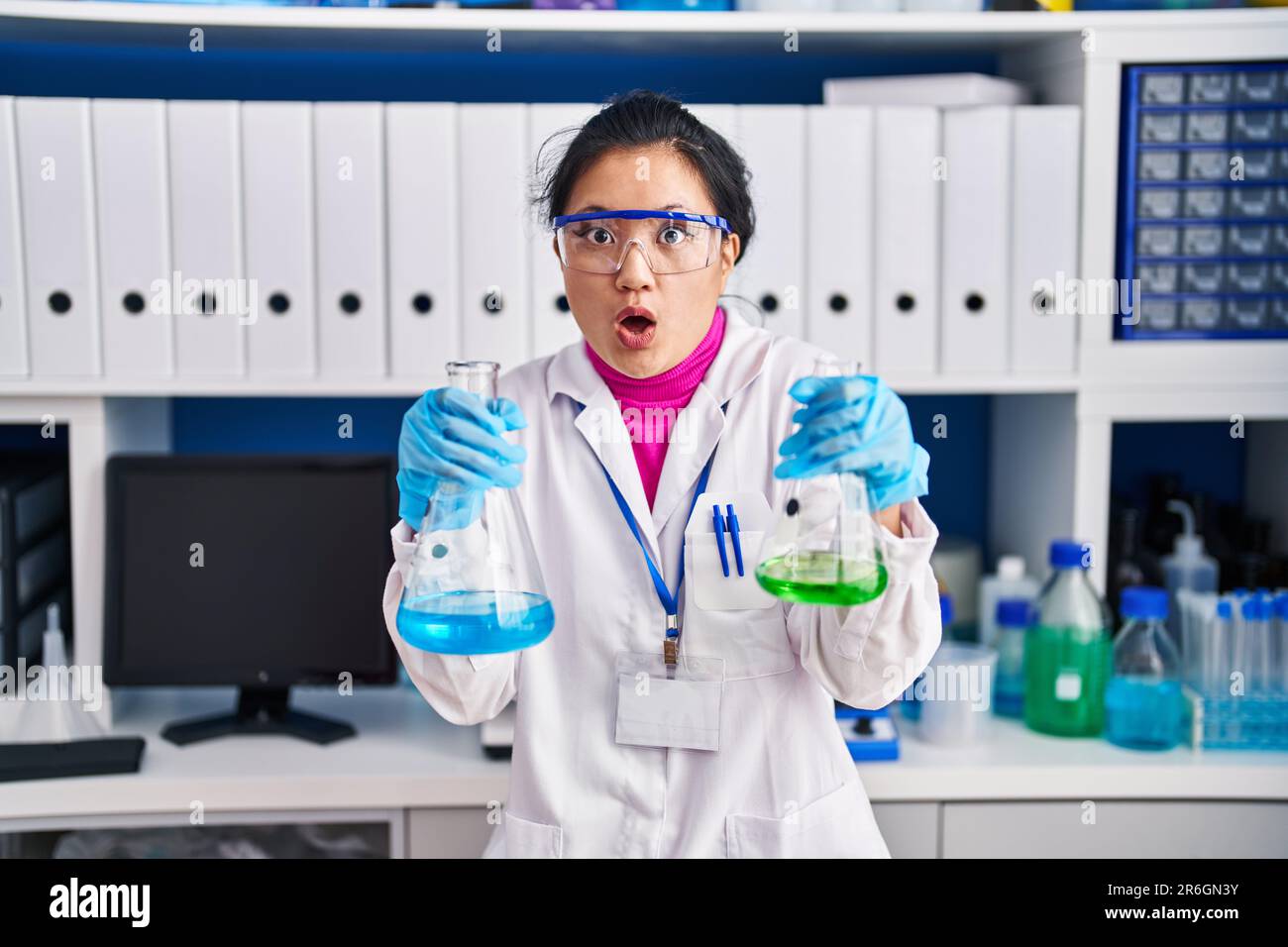 Young asian woman working at scientist laboratory afraid and shocked ...