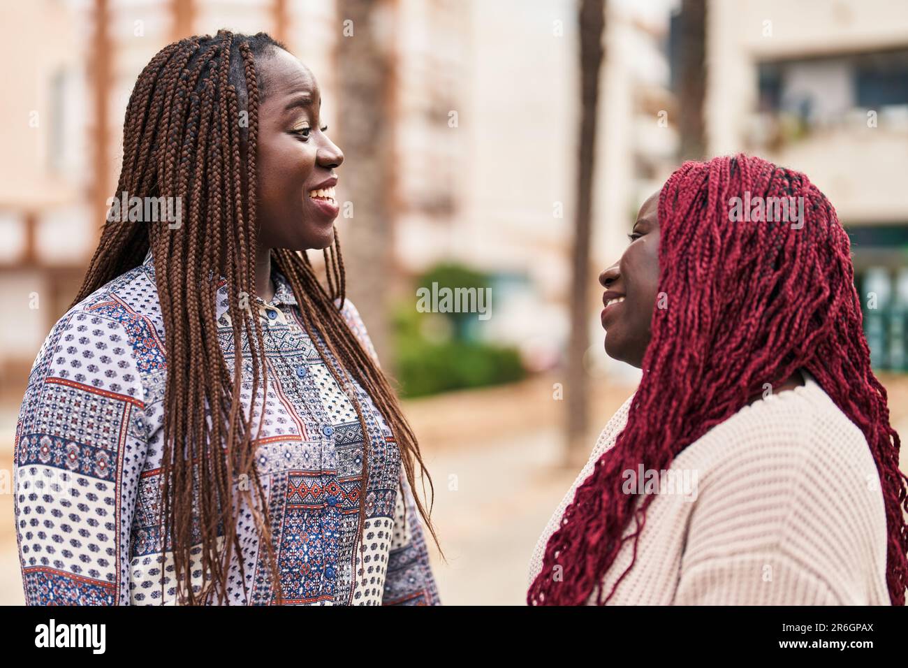 African american women friends standing together speaking at park Stock ...