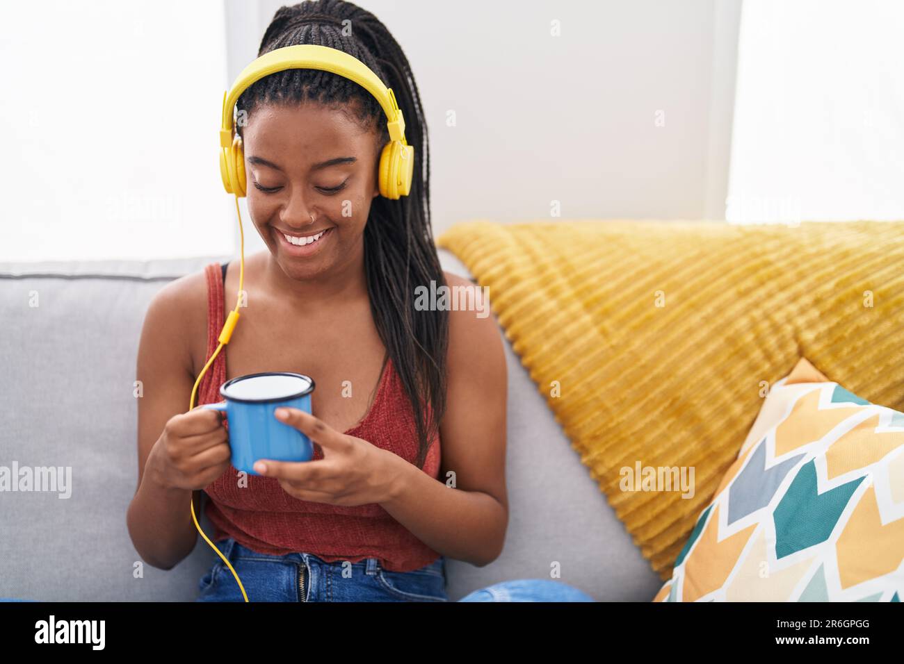 African american woman listening to music drinking coffee at home Stock ...