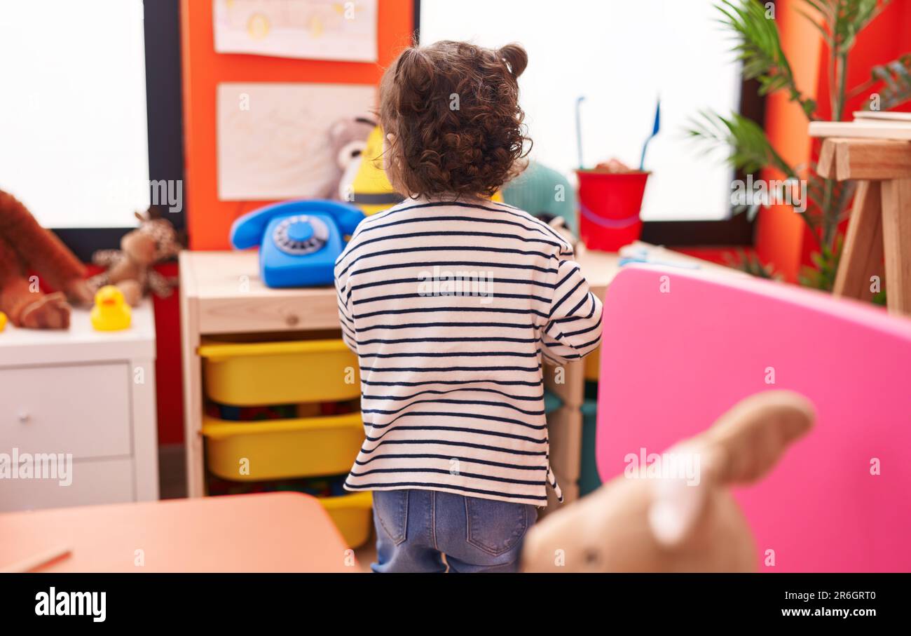 Adorable hispanic girl standing on back view at kindergarten Stock ...