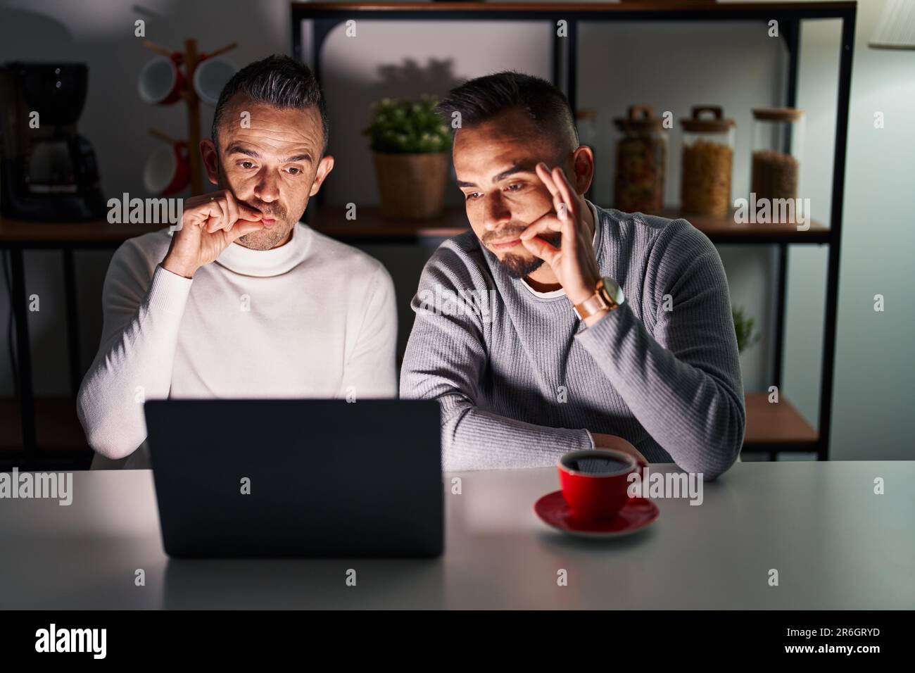 Homosexual couple using computer laptop mouth and lips shut as zip with ...