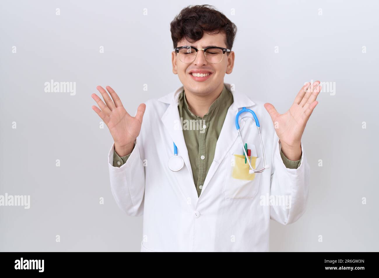 Young non binary man wearing doctor uniform and stethoscope celebrating ...