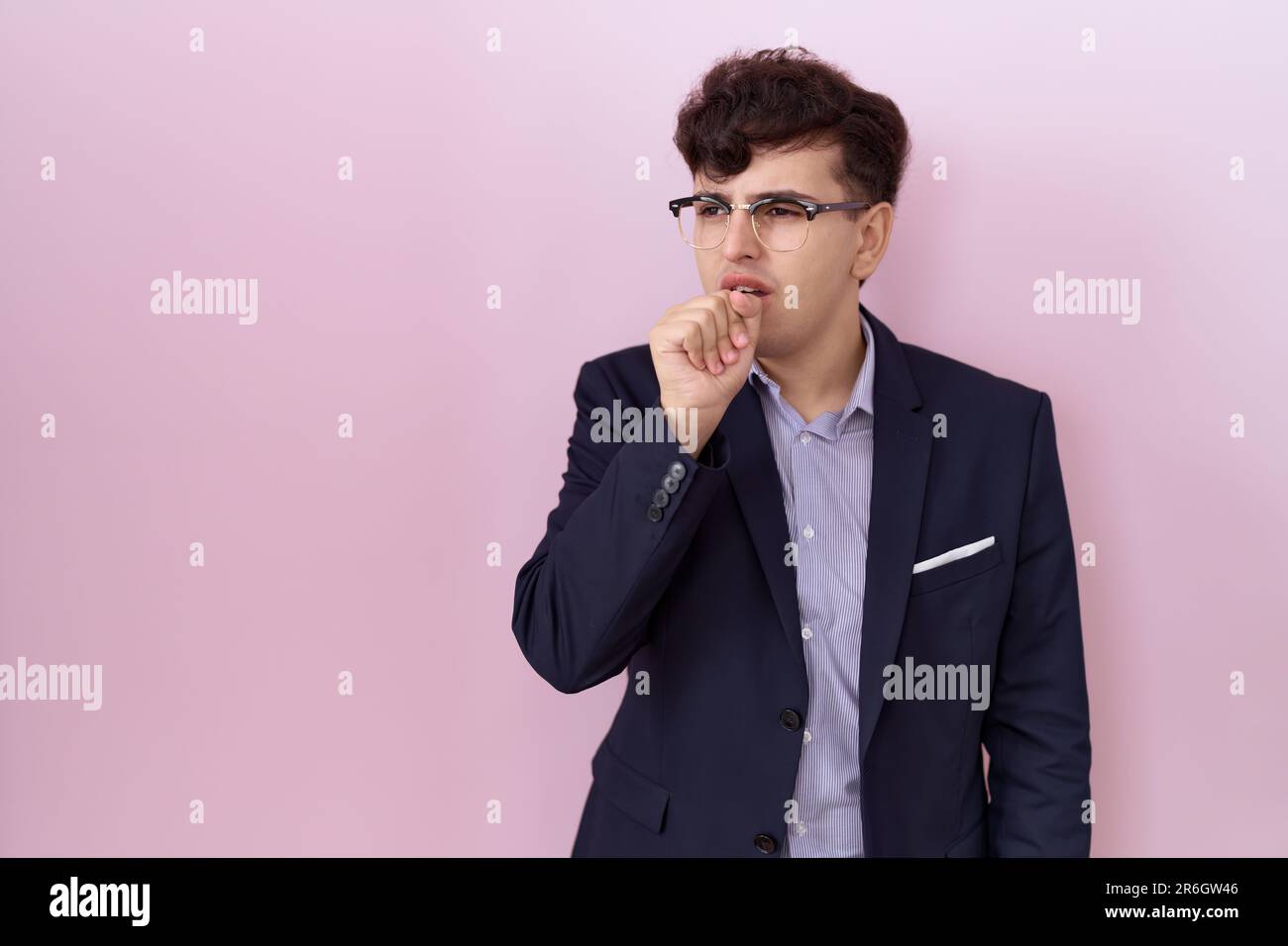 Young non binary man with beard wearing suit and tie feeling unwell and ...