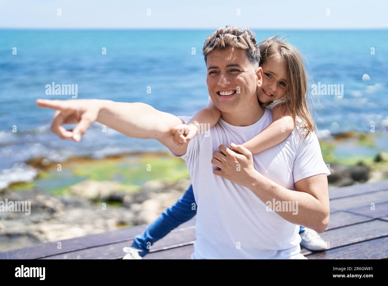 Father and daughter smiling confident hugging each other holding on back at seaside Stock Photo ...