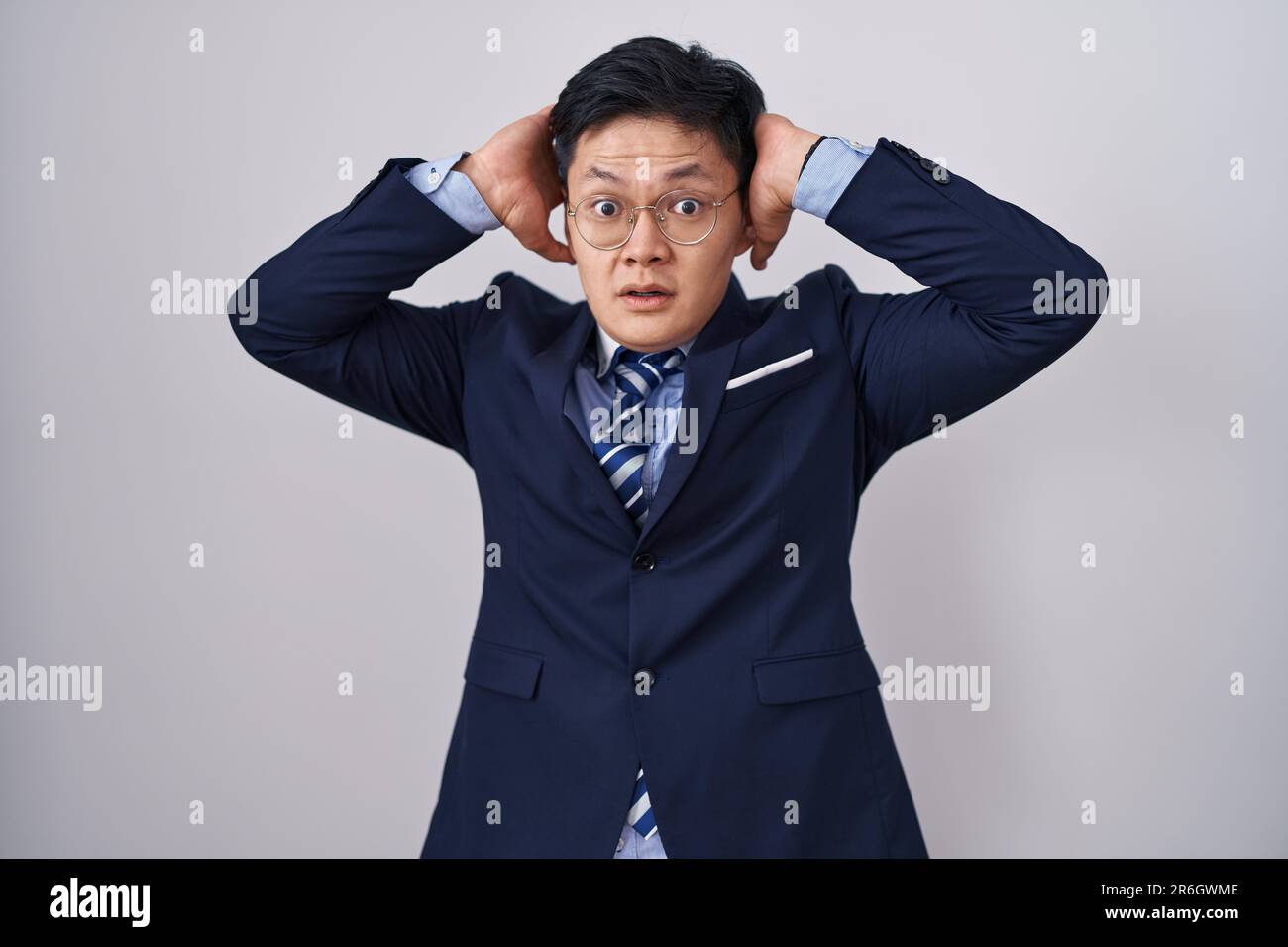 Young asian man wearing business suit and tie crazy and scared with ...