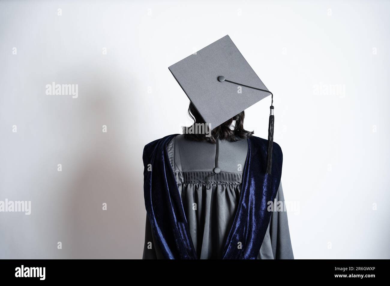 A clear photo of a girl wearing a graduation gown with white space for ...