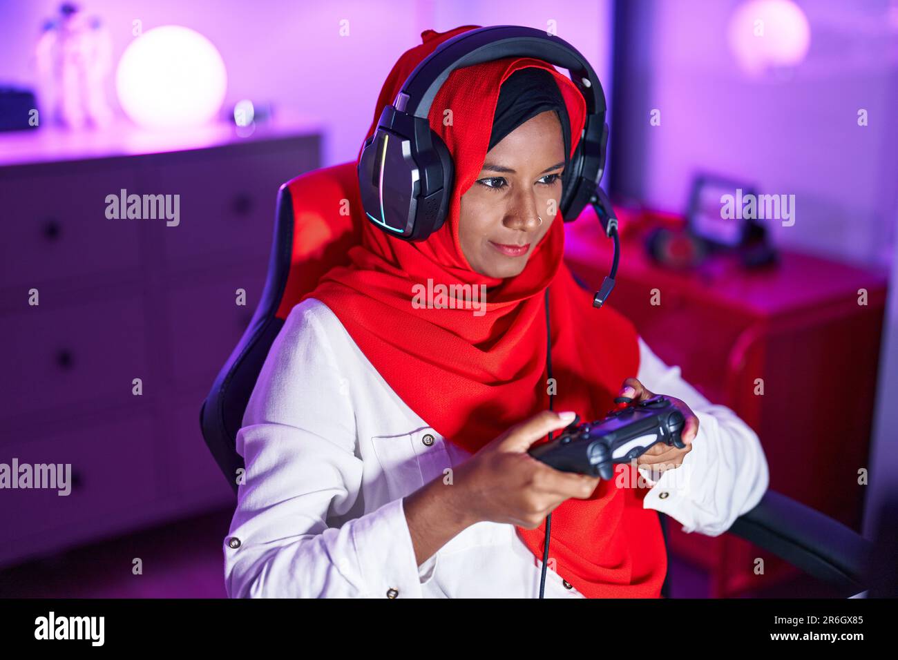 Young beautiful woman streamer playing video game using joystick at ...