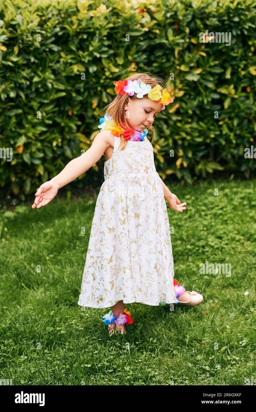 Outdoor portrait of adorable little girl playing in park, wearing white ...