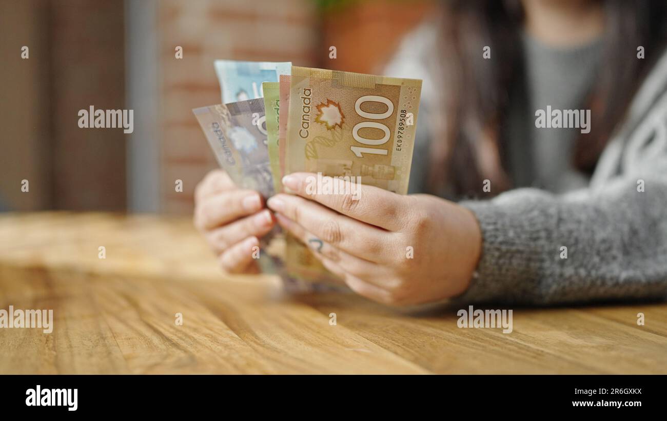Hands of woman counting canadian dollars at room Stock Photo - Alamy
