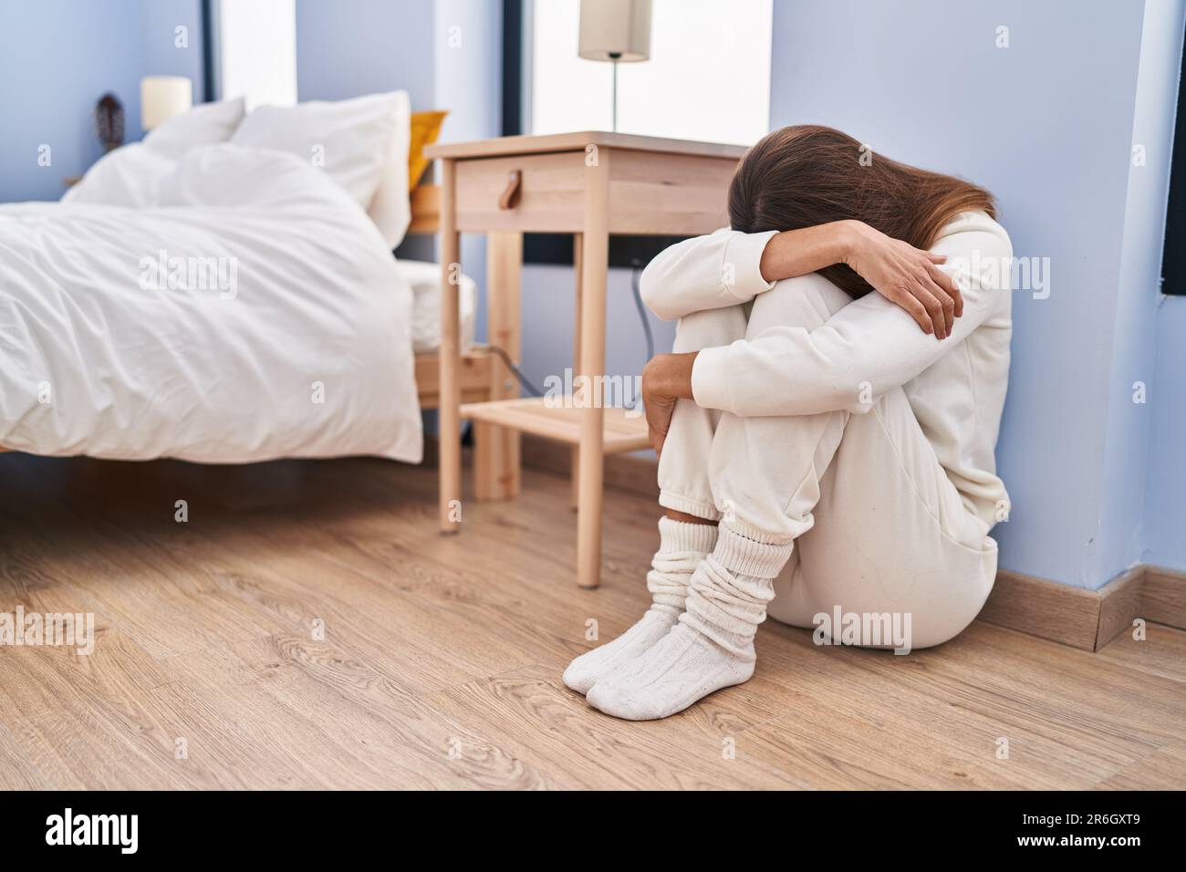 Young woman sitting on the floor crying at bedroom Stock Photo - Alamy