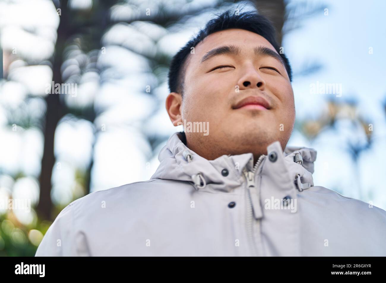 Young chinese man breathing standing at park Stock Photo - Alamy