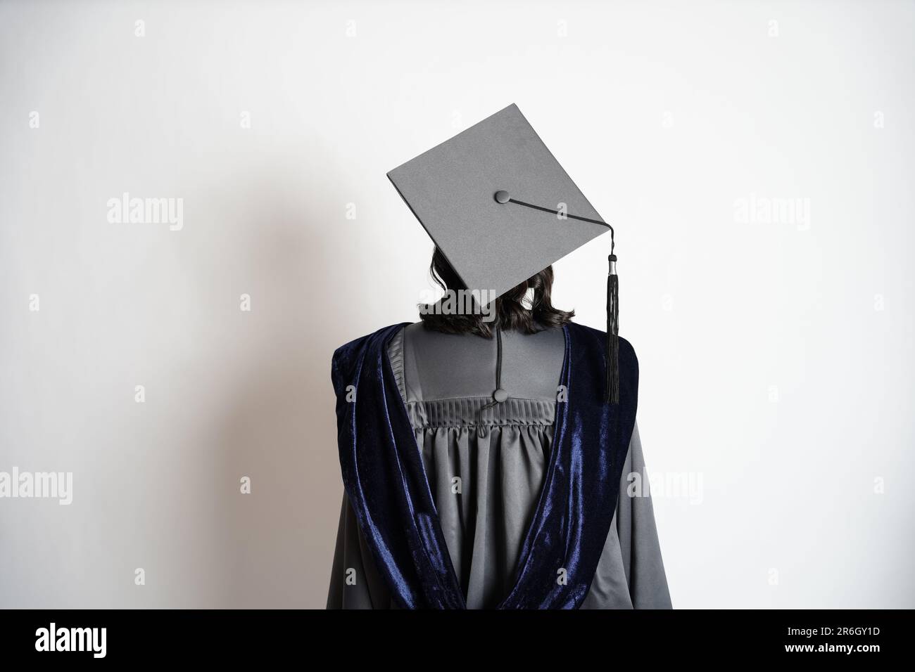 A clear photo of a girl wearing a graduation gown with white space for ...