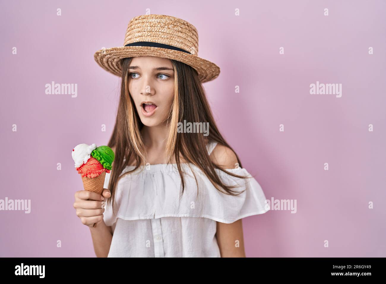 Teenager girl holding ice cream angry and mad screaming frustrated and ...