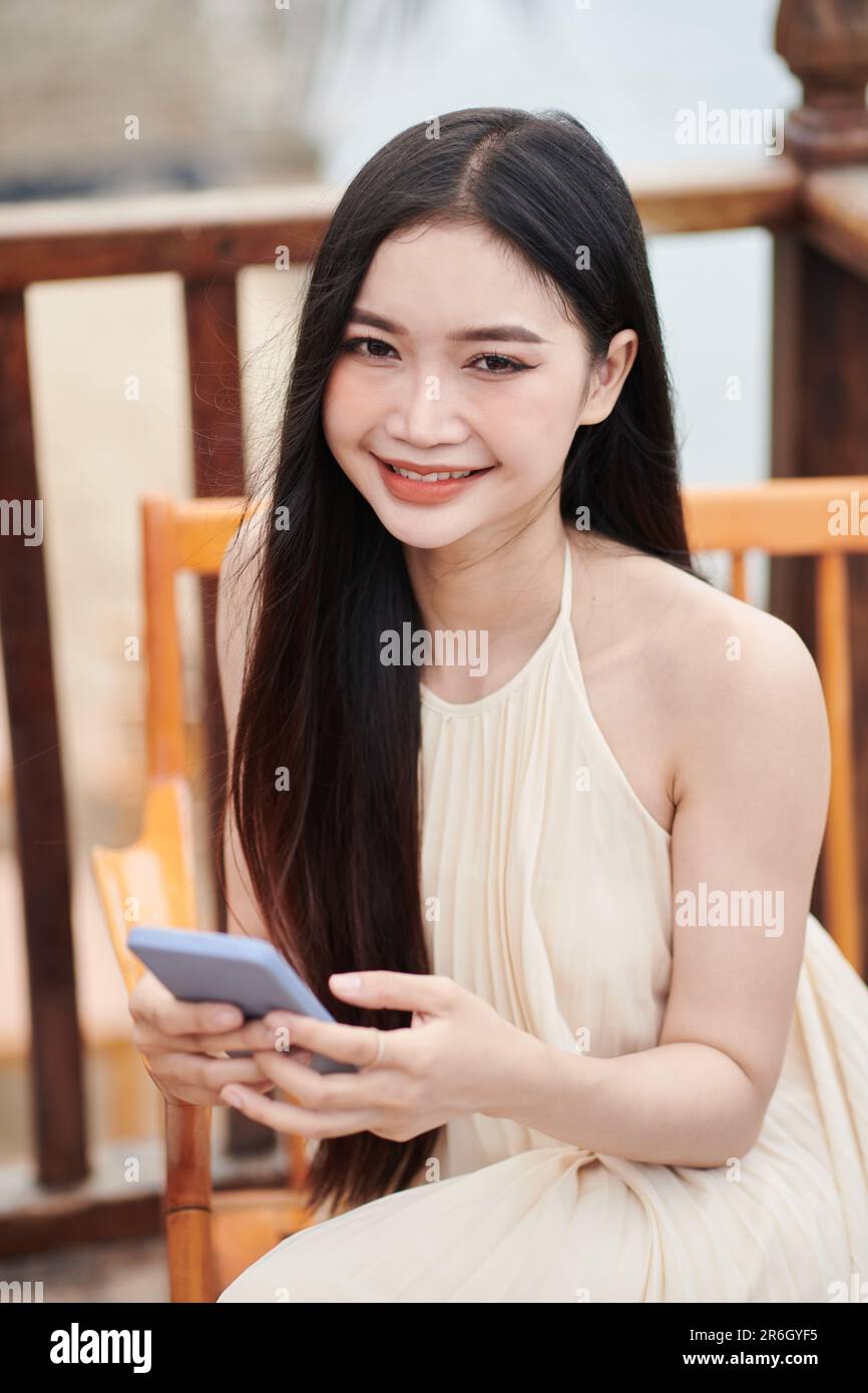 Portrait of happy young woman with long hair posting picture on social ...