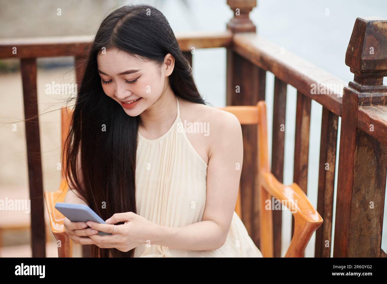Cheerful young woman answering text messages from friends or boyfriend ...