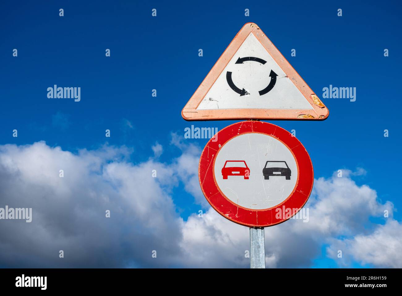 two traffic signs, one for roundabout warning and the other one for no ...