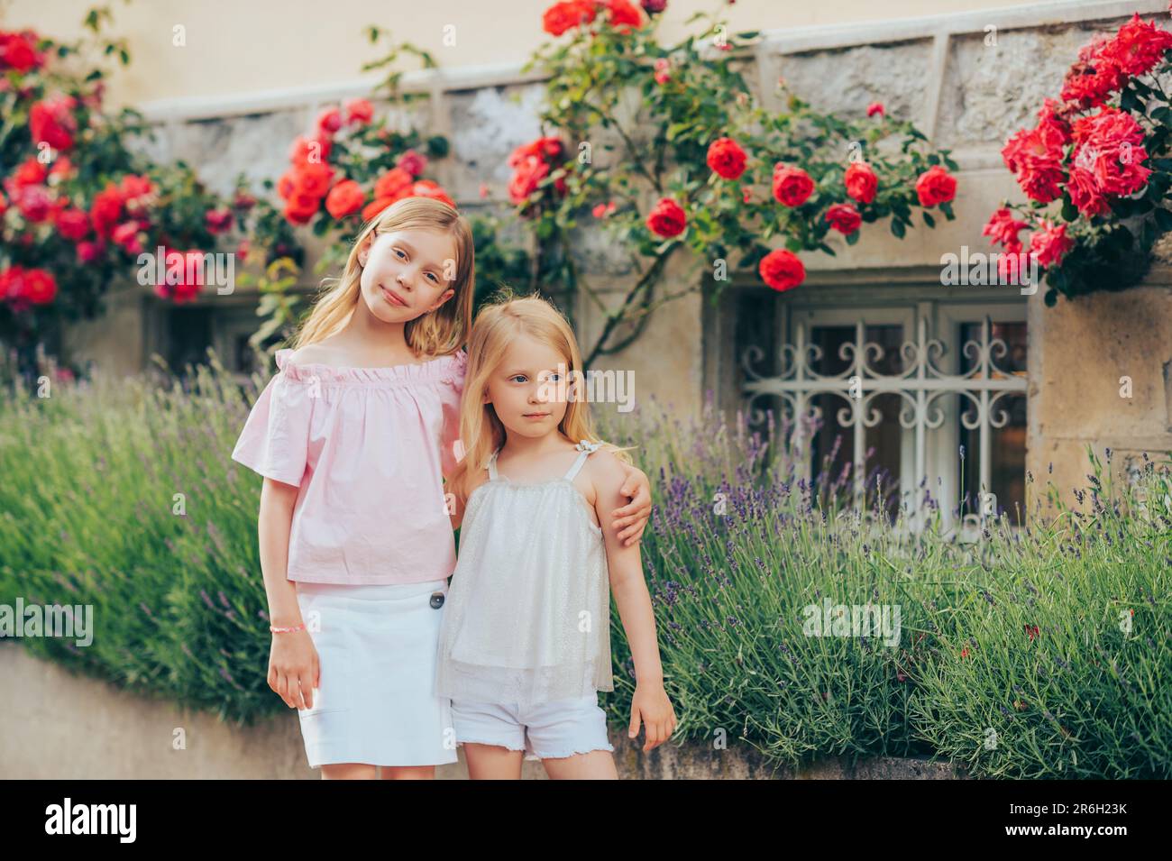 Outdoor portrait of two sweet little girls, kids playing together ...