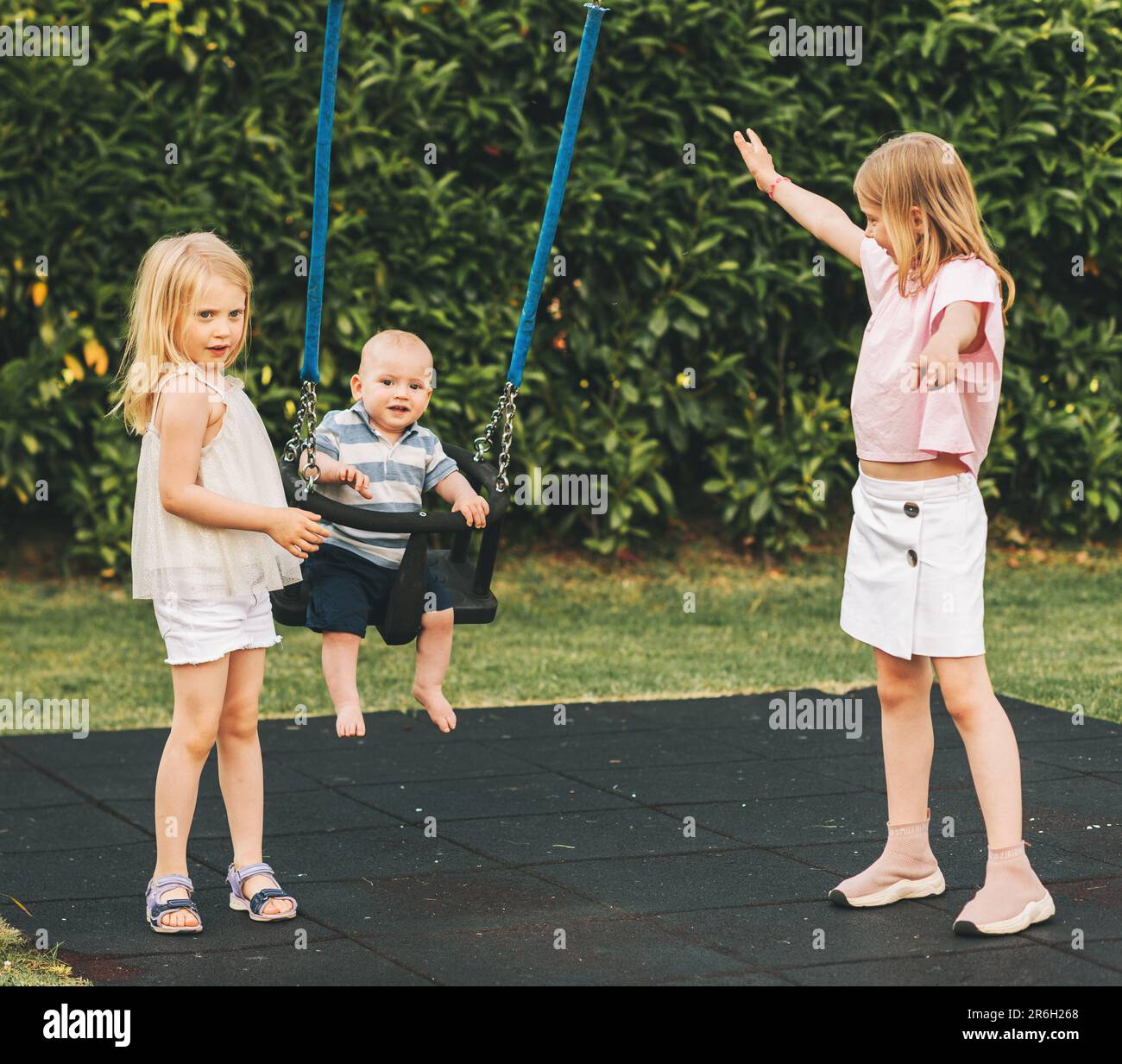 Family of 3 kids playing together outside, big sisters taking care of ...