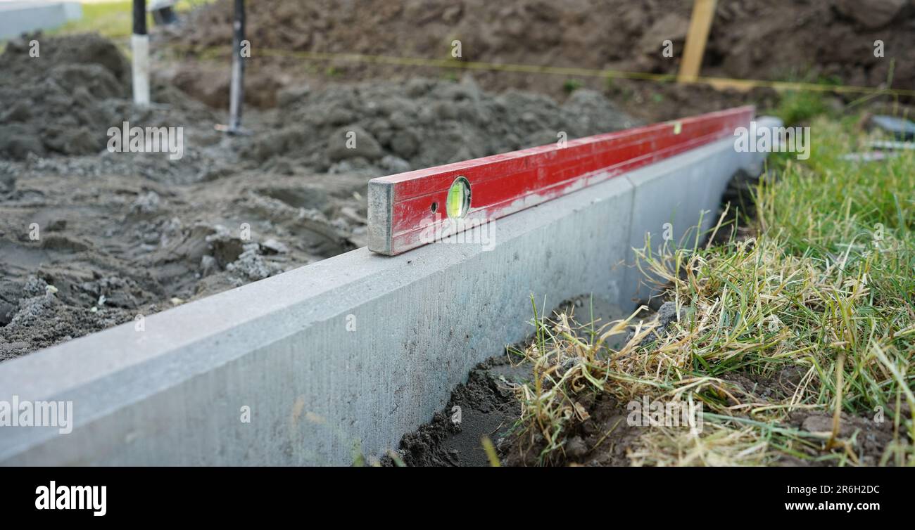 Level on the concrete kerb. Leveling on the construction site. Work ...