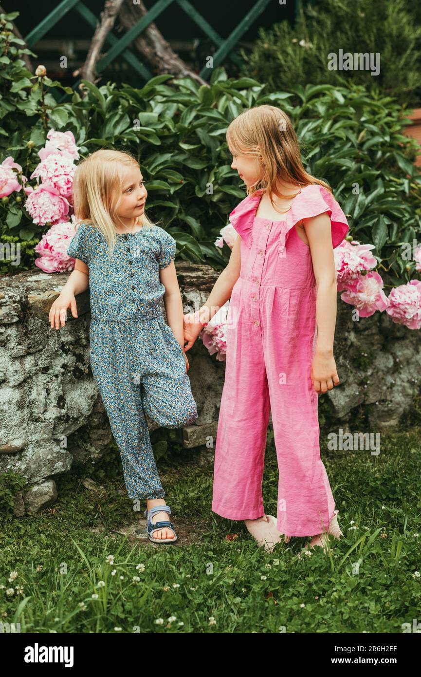 Outdoor portrait of two sweet little girls, kids playing together in ...