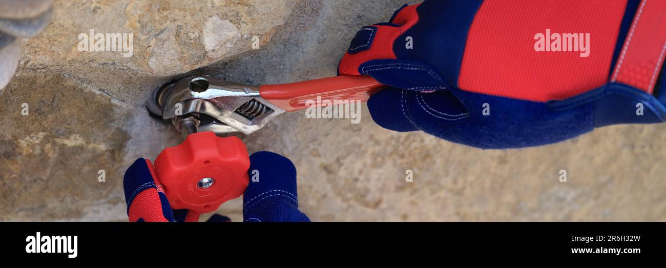 Male hands in work gloves repairing tap outside using wrench Stock ...