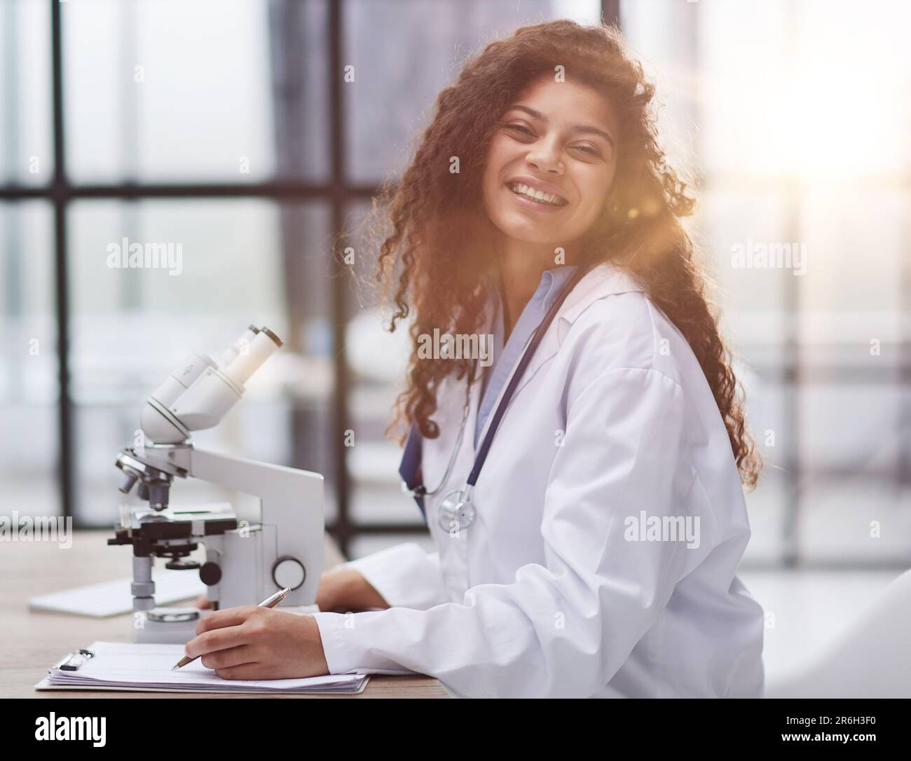 Attractive female scientist looking through a microscope Stock Photo ...