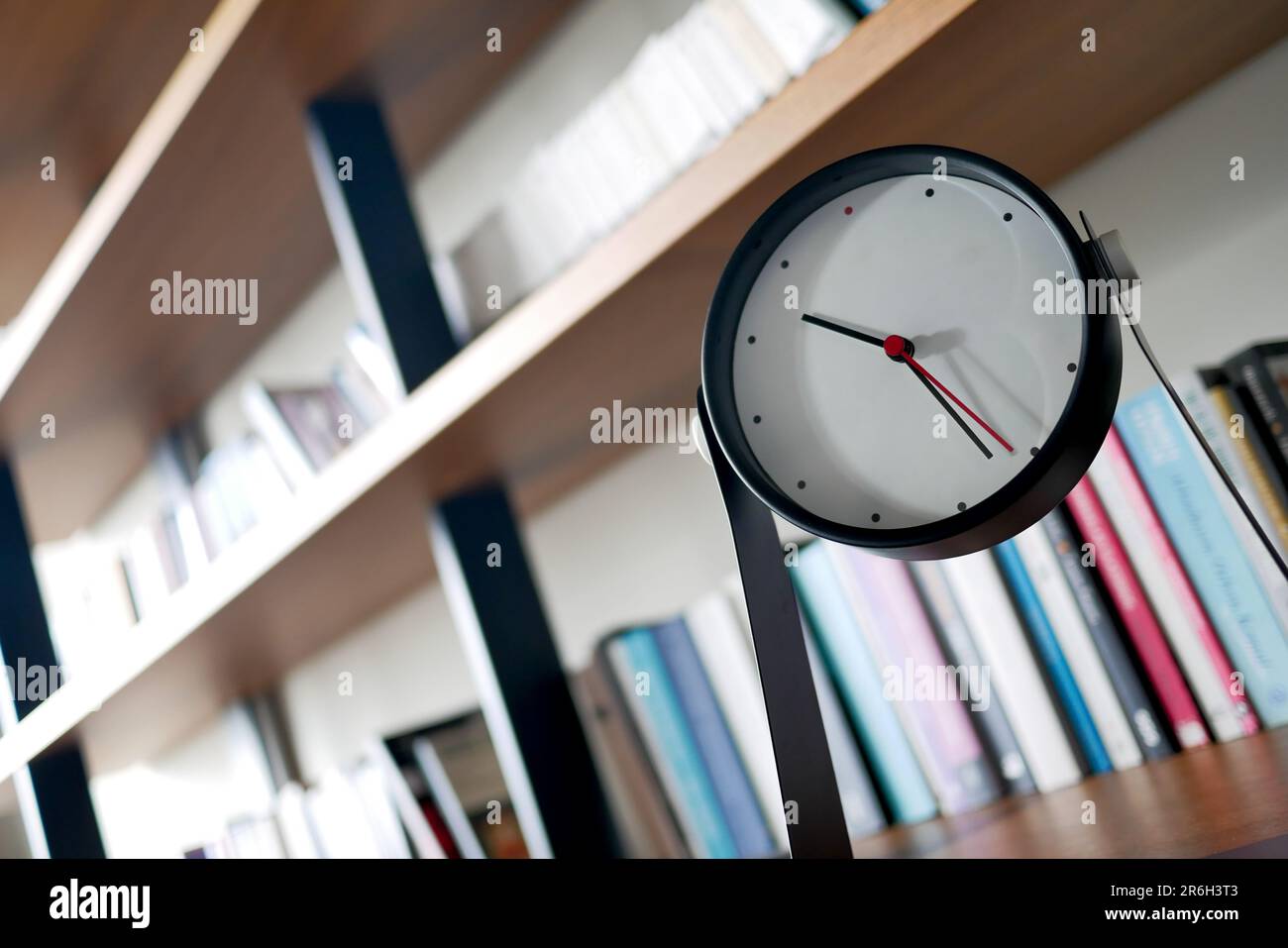 simple modern clock on a book shelf Stock Photo - Alamy