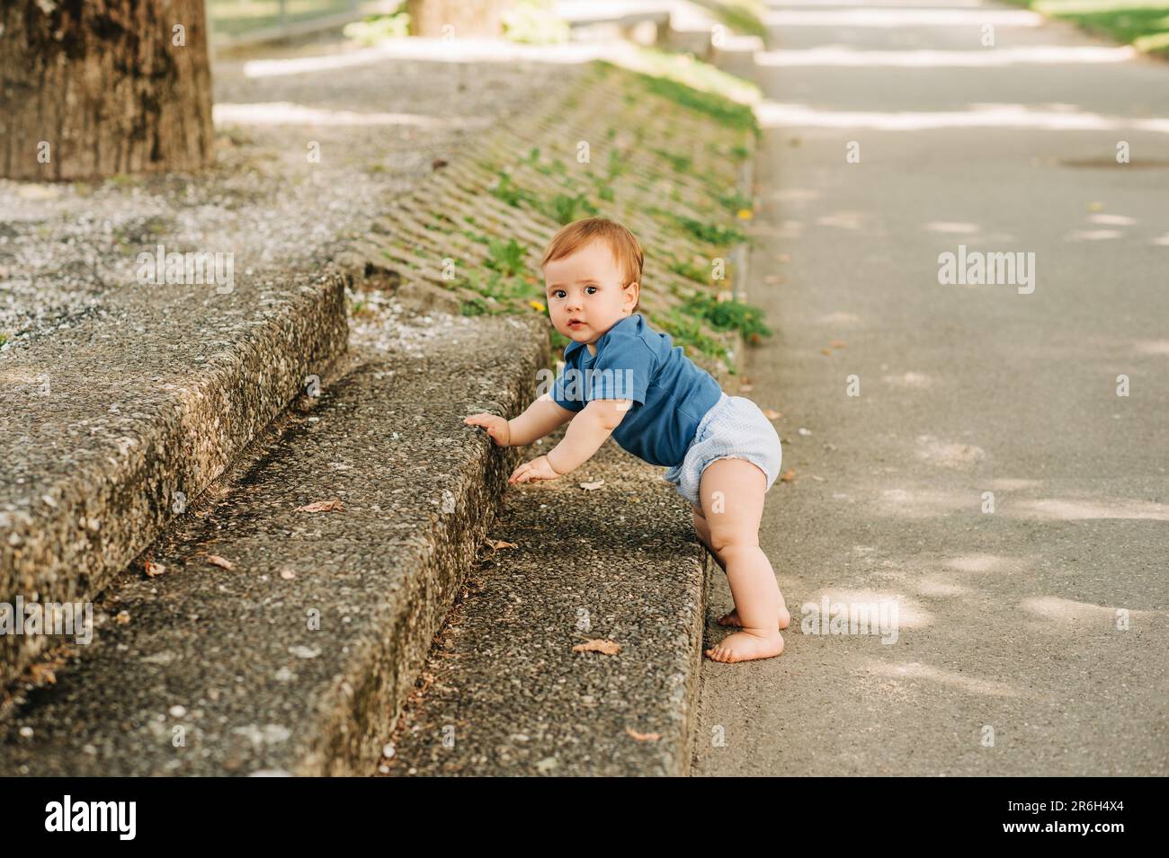 Adorable baby boy climbing up the stairs in the park Stock Photo - Alamy