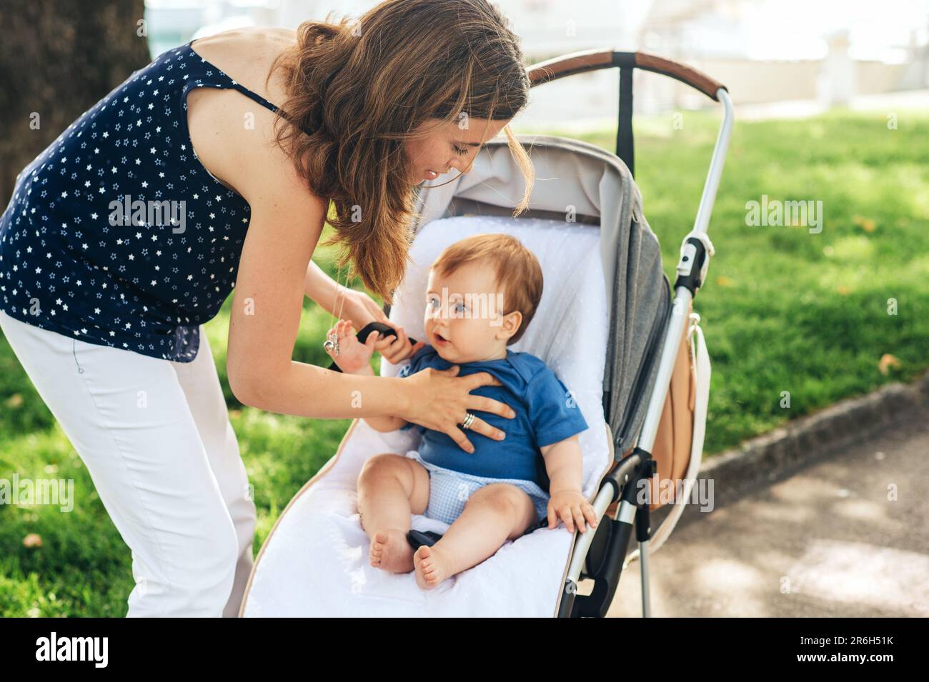 Young mother putting baby in a buggy Stock Photo - Alamy
