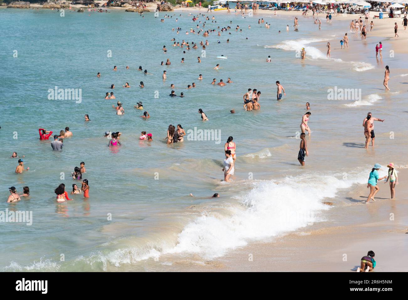 A group of people gathering on the beach near the shoreline Stock Photo ...