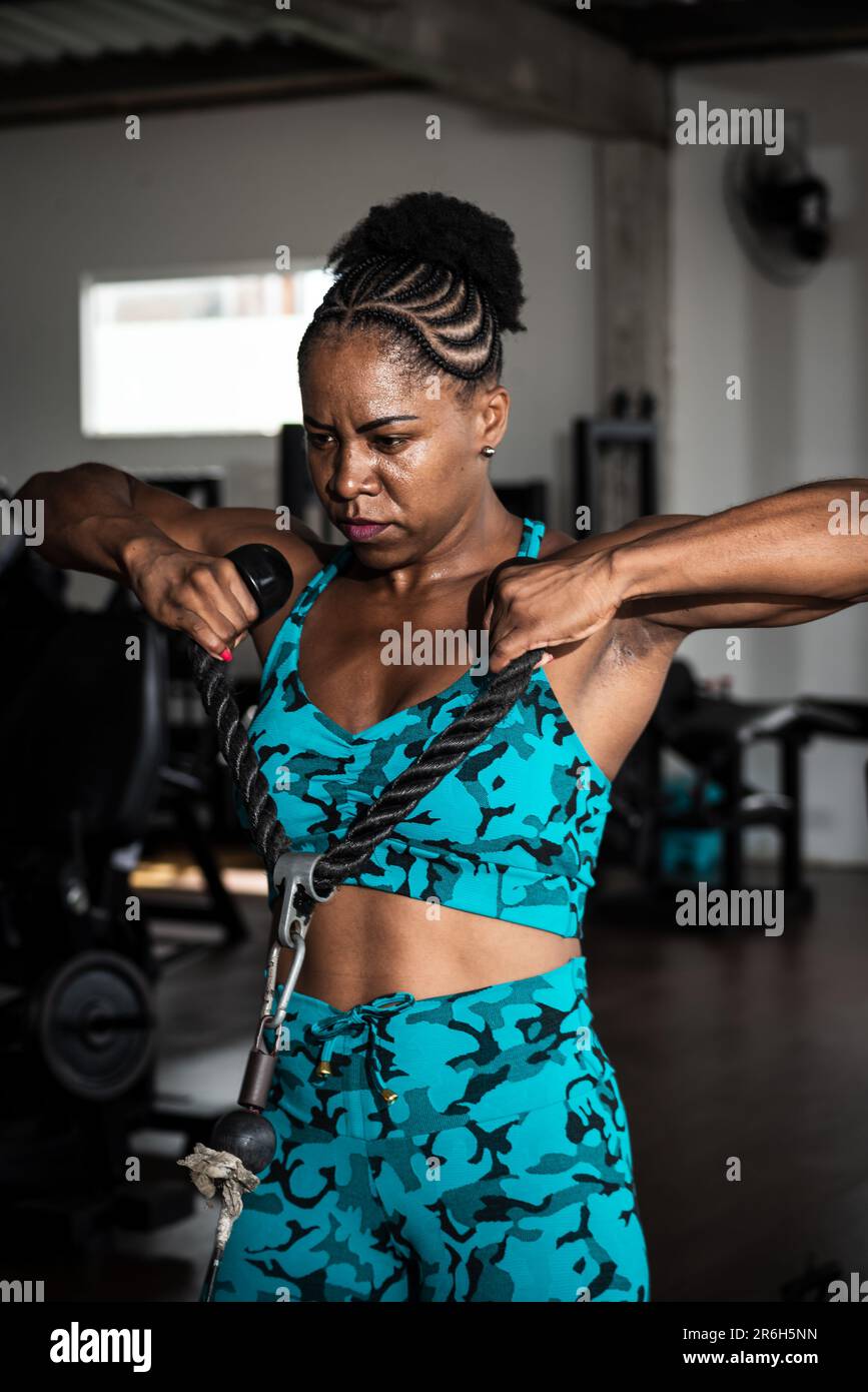 A female athlete is performing a strength training exercise in a gym ...