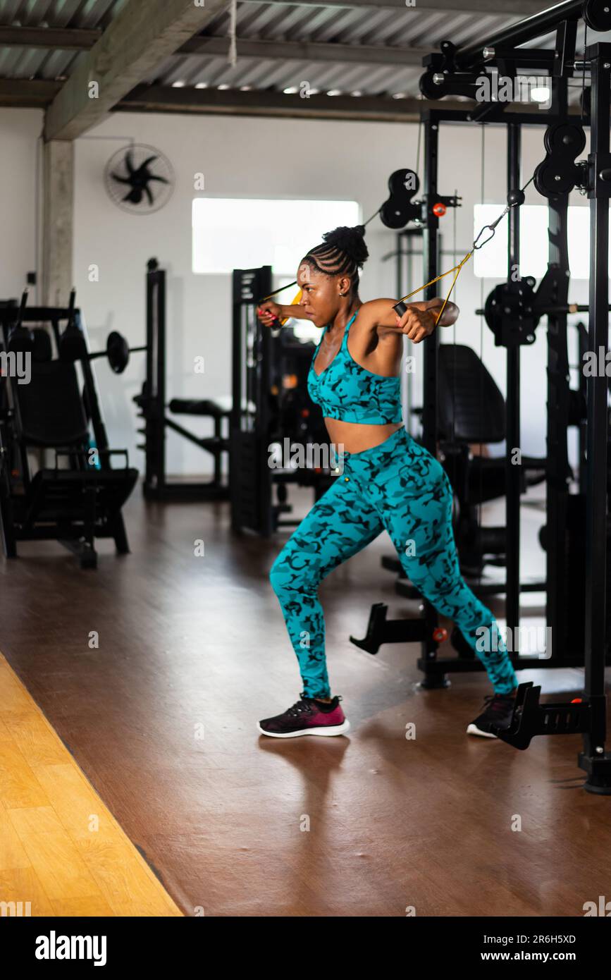 A fit female athlete is in an active pose as she jumps to pull a ...