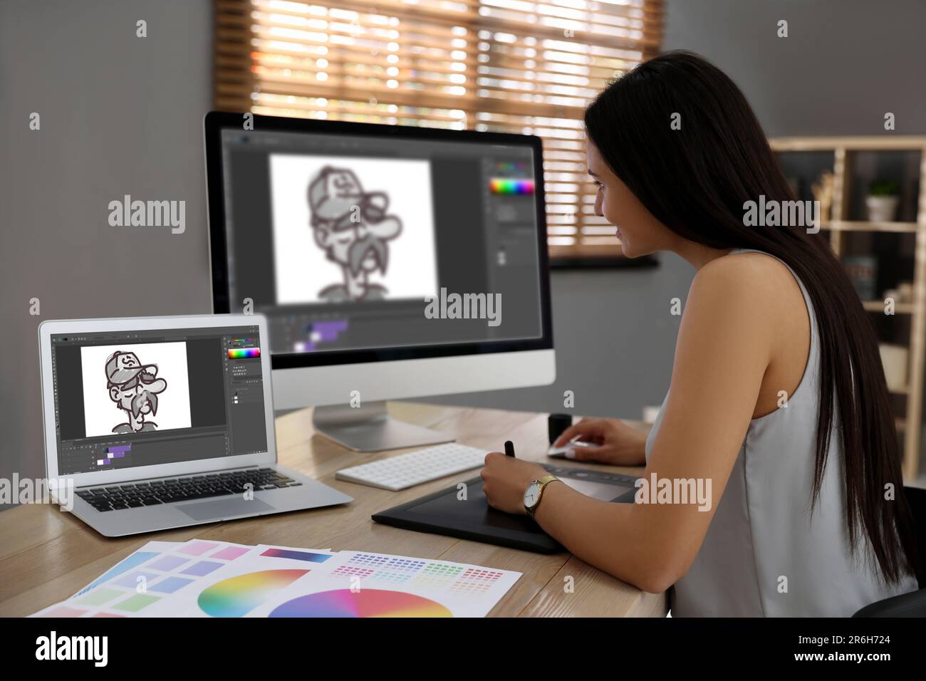 Animator working with graphic tablet, computer and laptop ...
