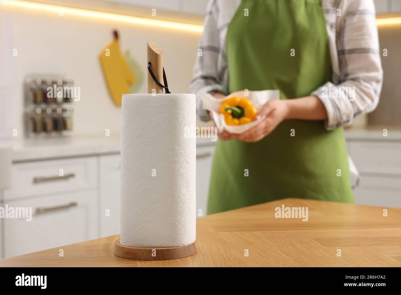 Roll of paper towels in kitchen and woman wiping bell pepper on ...