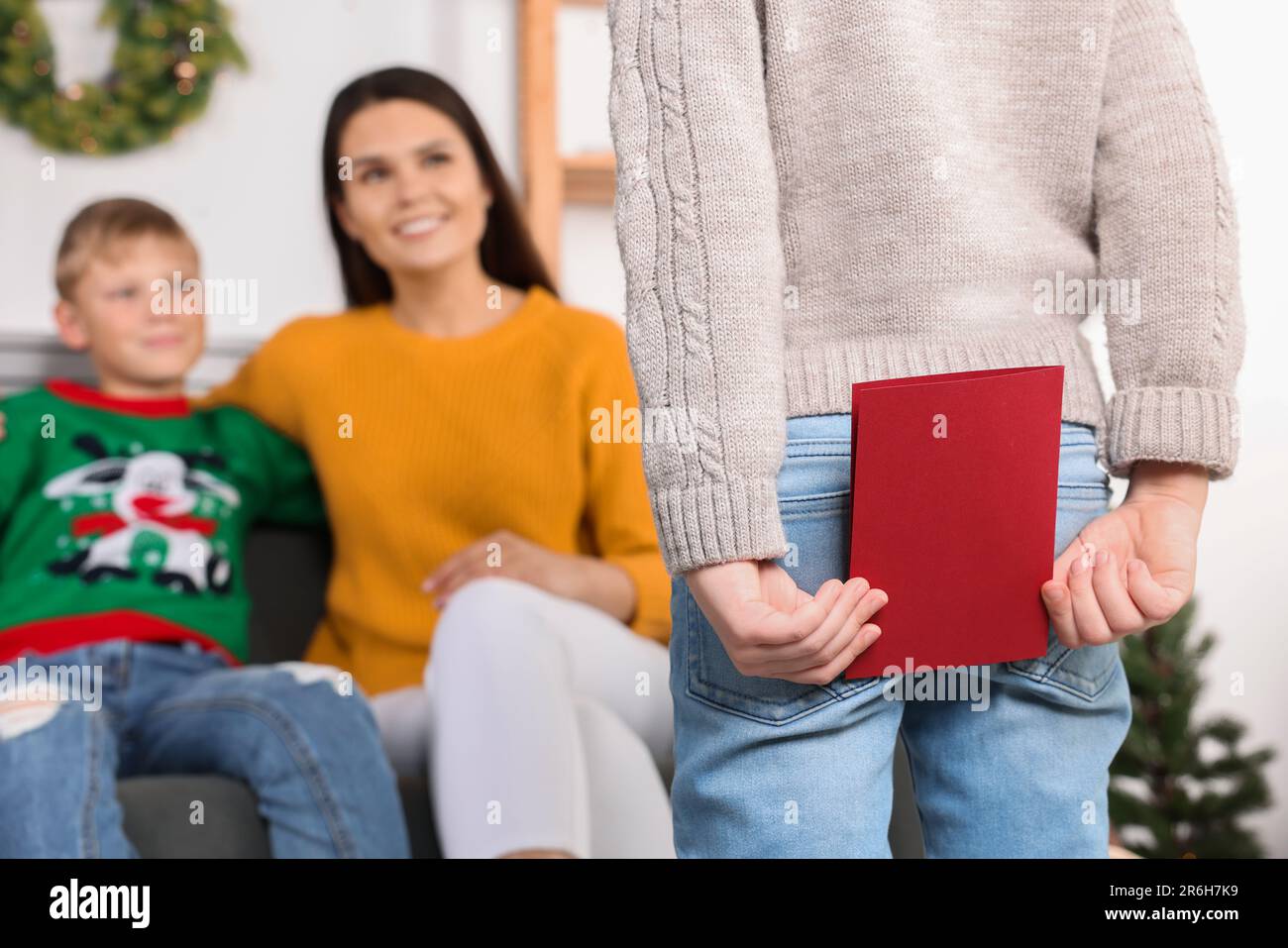 Happy woman receiving greeting card from her daughter at home, closeup ...