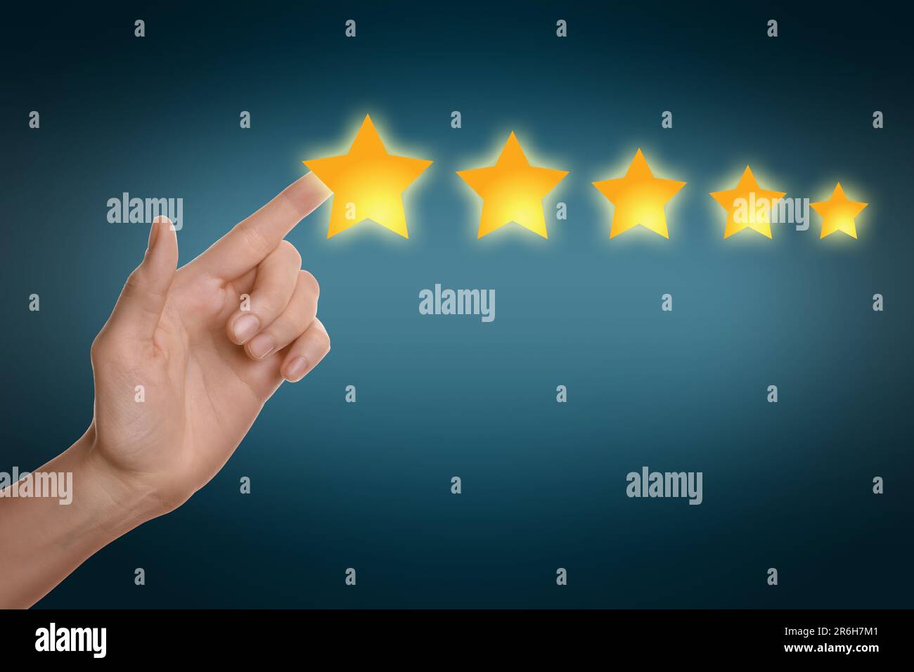 Quality rating. Woman pointing at stars against blue background ...