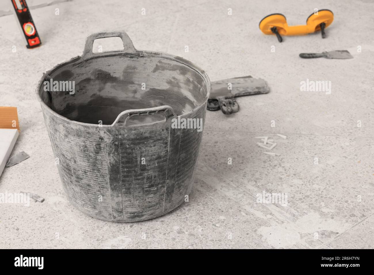 Bucket and different equipment on floor indoors. Tiles installation ...