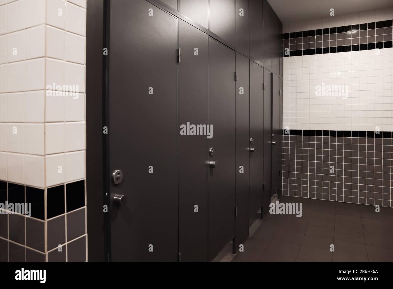 Public toilet interior with stalls and tiled walls Stock Photo - Alamy