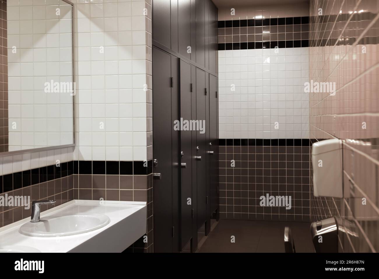 Public toilet interior with sinks, stalls and mirror Stock Photo - Alamy