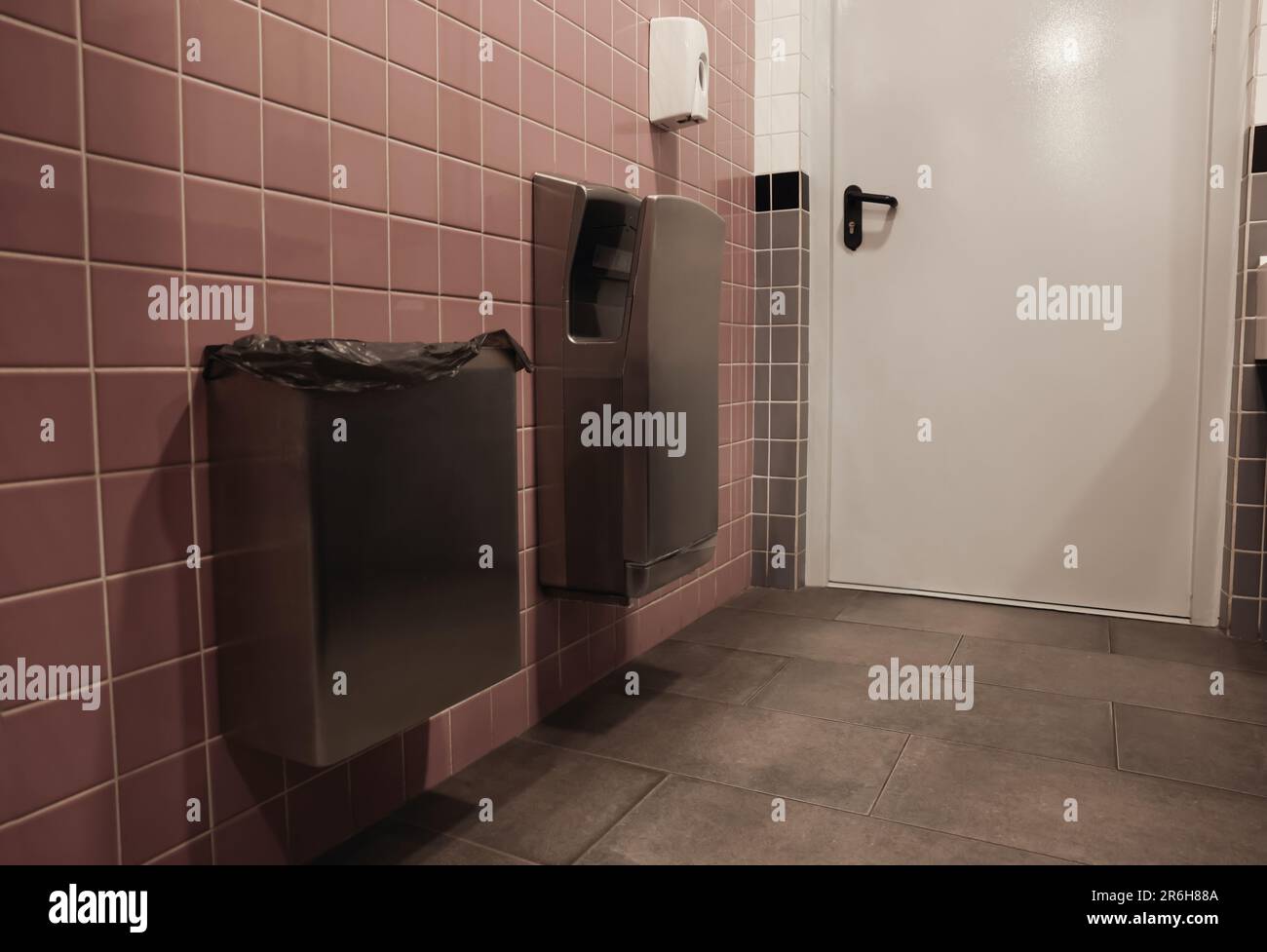 Hand dryer and trash can on tiled wall in public toilet Stock Photo - Alamy