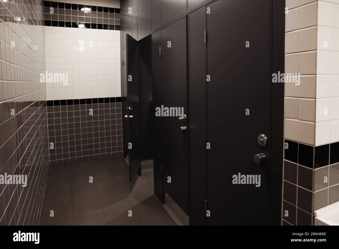 Public toilet interior with stalls and tiled walls Stock Photo - Alamy