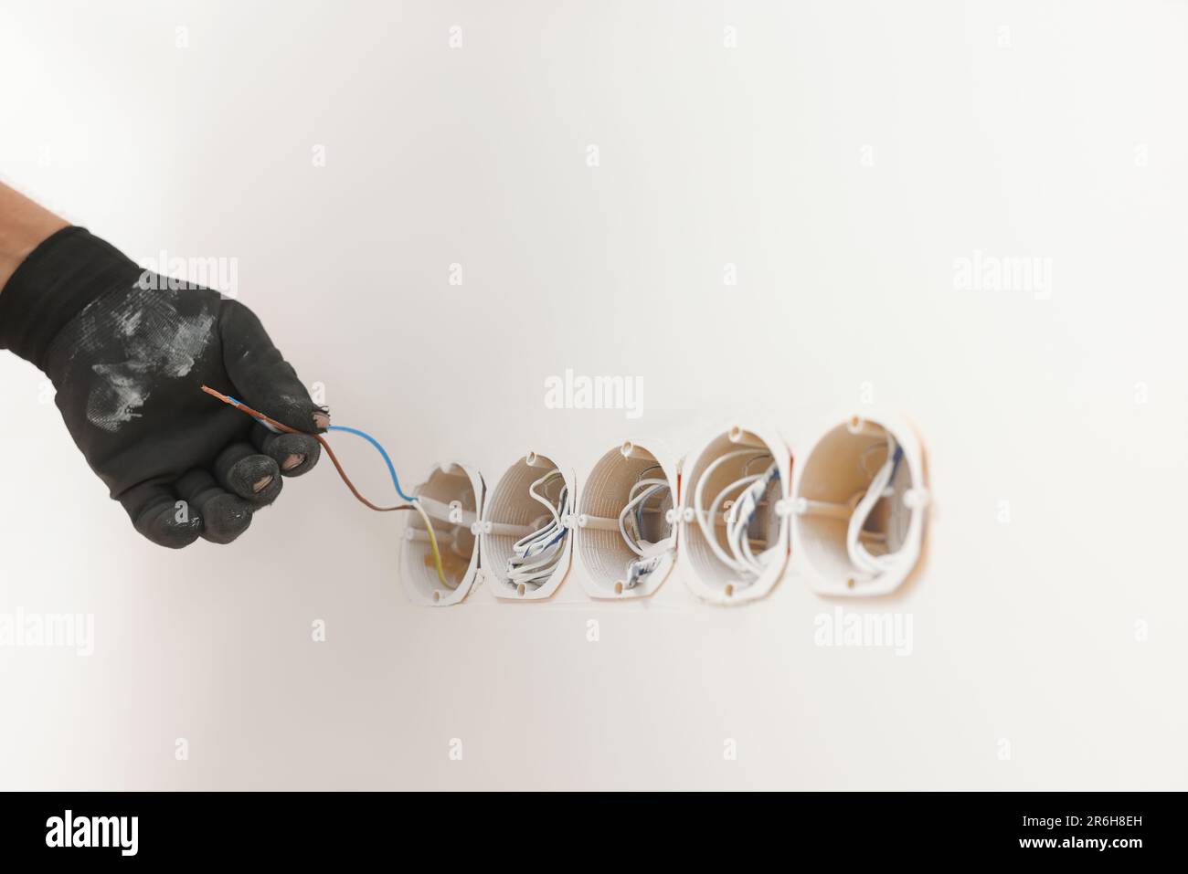 Handyman installing sockets in white wall, closeup Stock Photo - Alamy