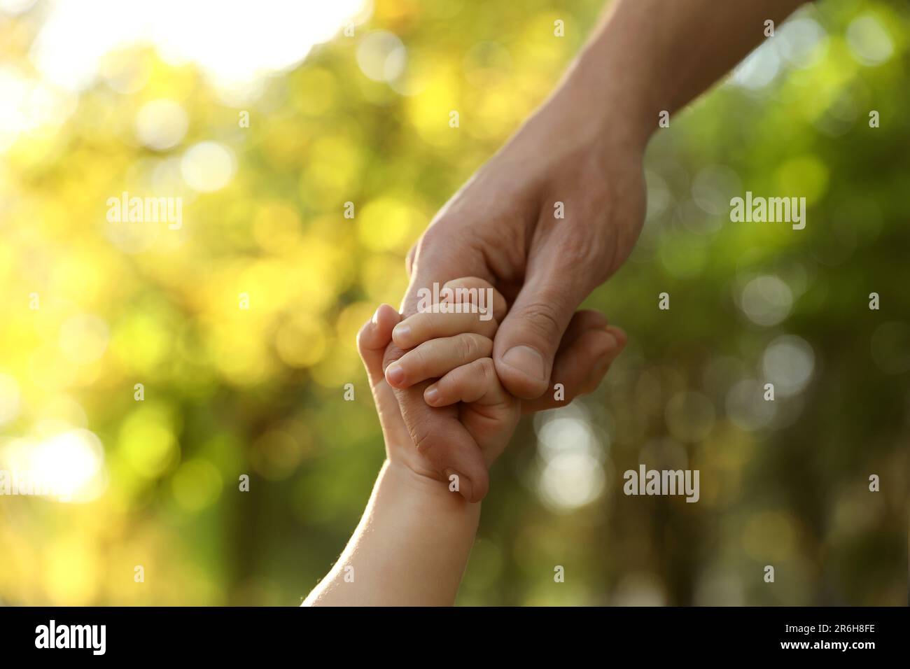 Daughter holding father's hand outdoors, closeup. Happy family Stock ...