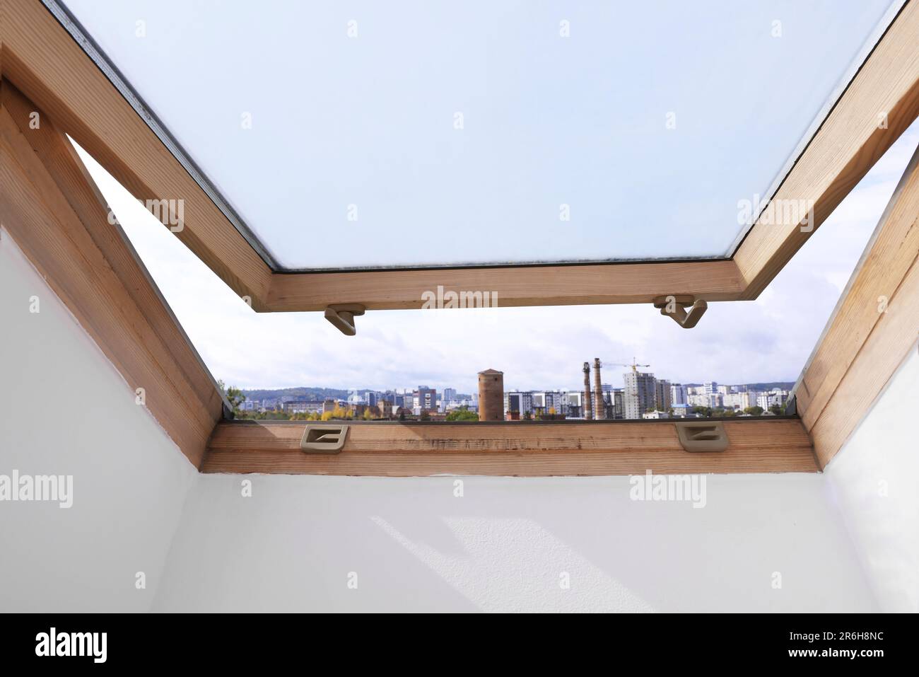Beautiful view of cityscape from open skylight roof window on slanted ceiling. Attic room Stock ...