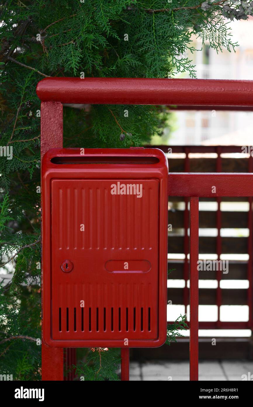 Red beautiful metal letter box near tree outdoors Stock Photo - Alamy