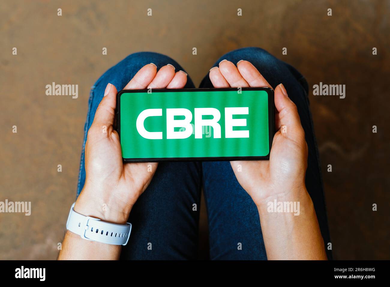 In this photo illustration, the CBRE Group logo is displayed on a smartphone screen Stock Photo ...