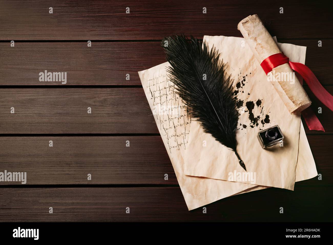 Inkwell, feather pen and vintage parchment with ink stains on wooden ...