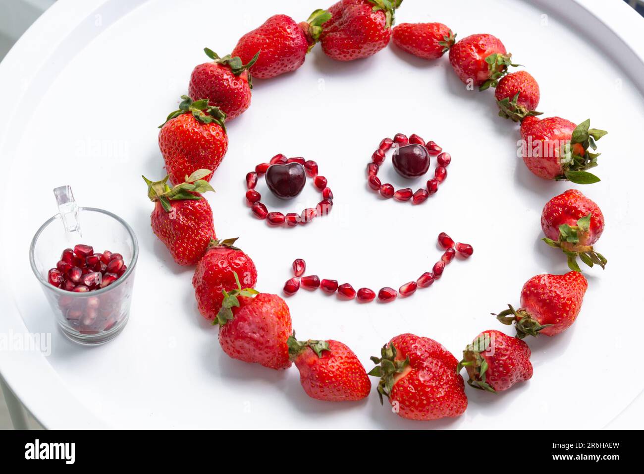 Cheerful emoticon - smile from red berries on the white table Stock ...